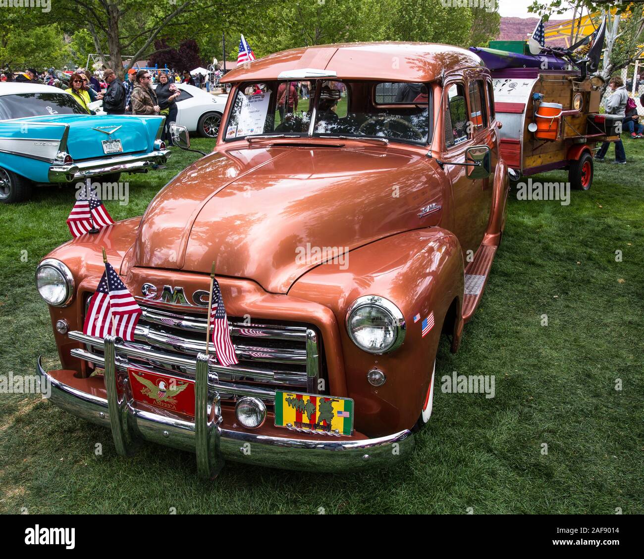 A restored and modified 1953 GMC Suburban with a custom camping trailer ...
