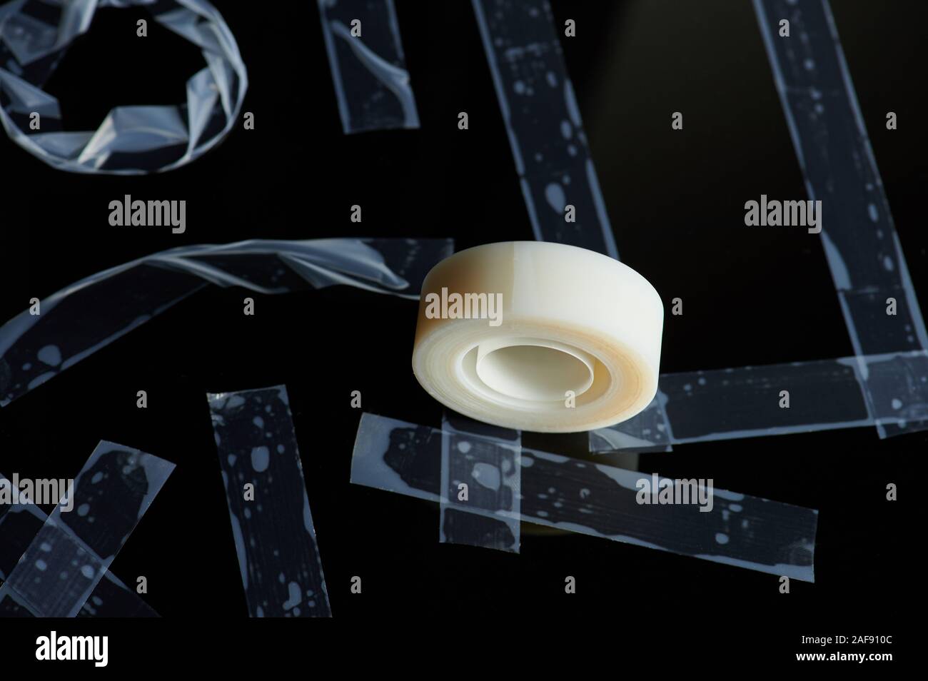 White sticky masking tape roll on black background Stock Photo - Alamy
