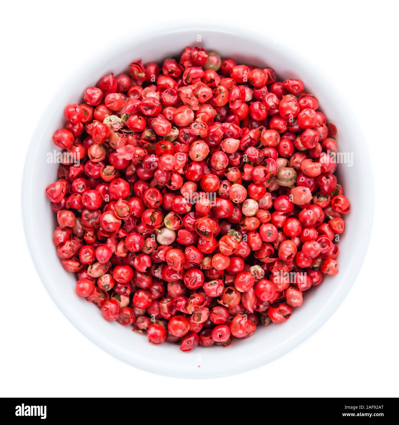 Portion of Pink Peppercorns as detailed close-up shot isolated on white ...