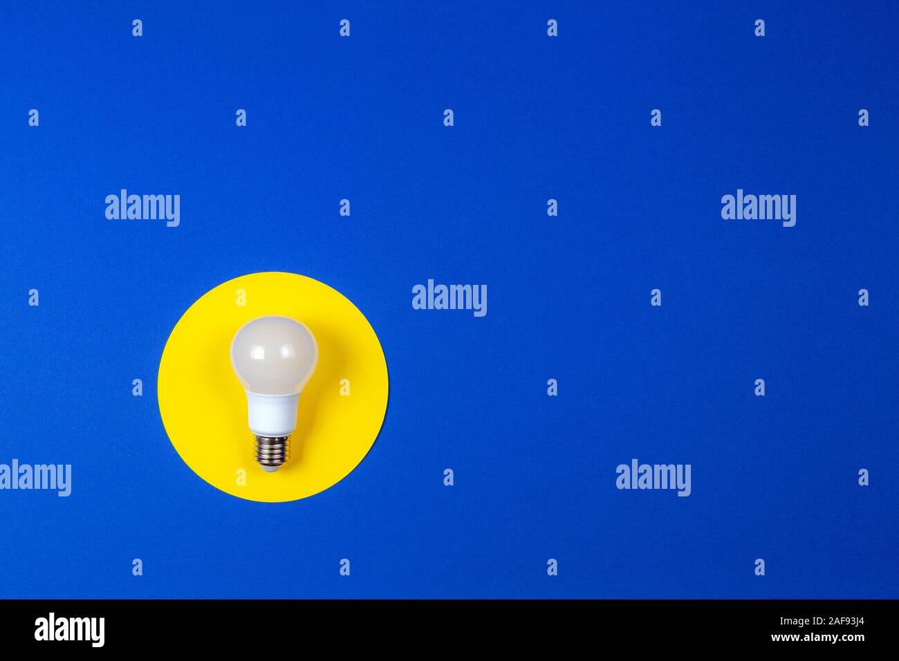 One light lamp bulb on yellow and navy blue background Stock Photo - Alamy