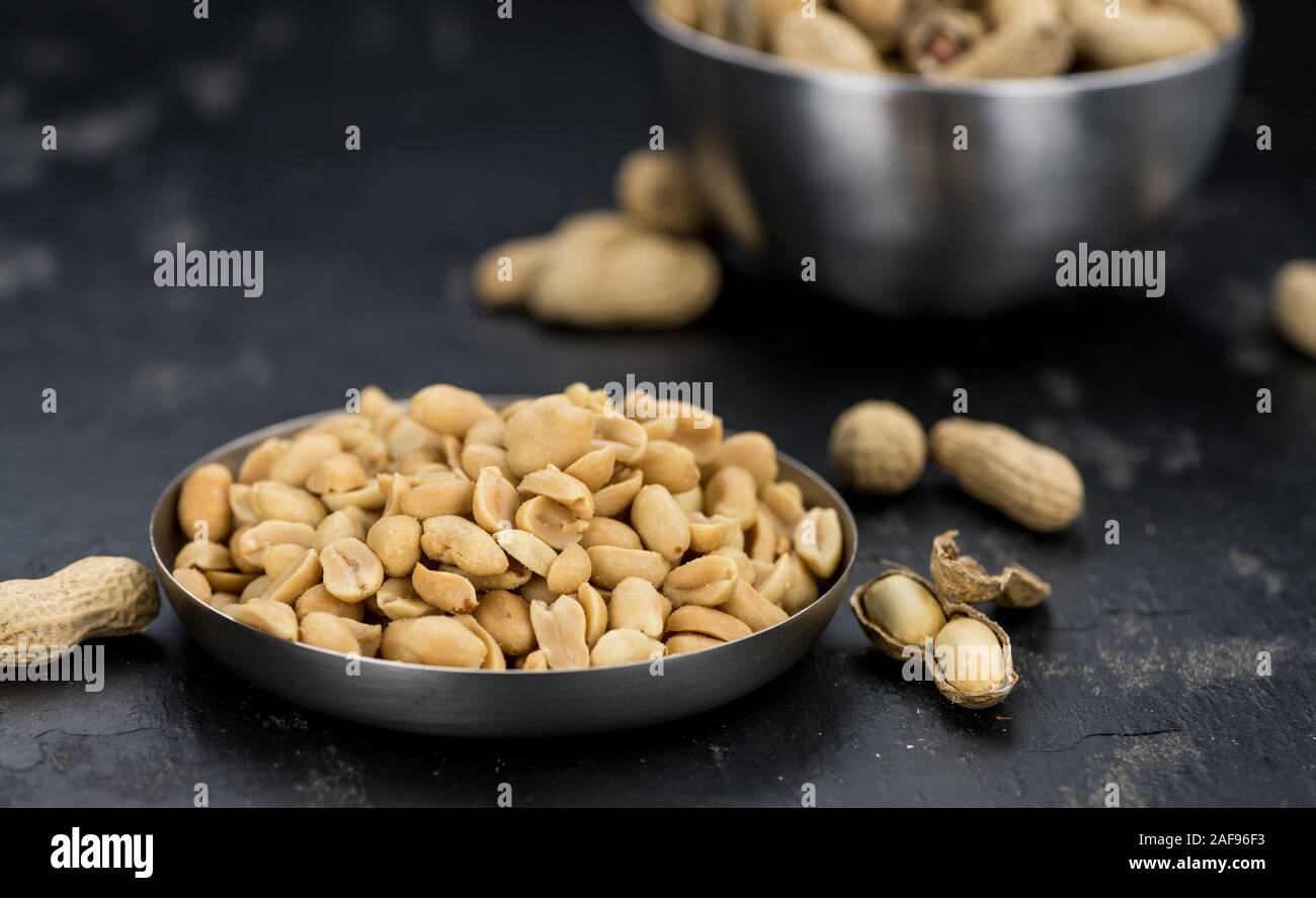 Roasted and salted Peanuts on vintage background (close-up shot ...