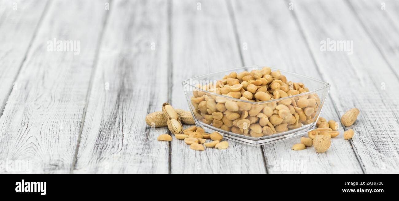Roasted and salted Peanuts on vintage background (close-up shot ...