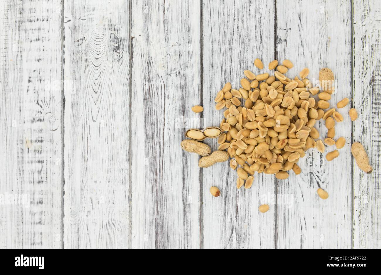 Roasted and salted Peanuts on vintage background (close-up shot ...