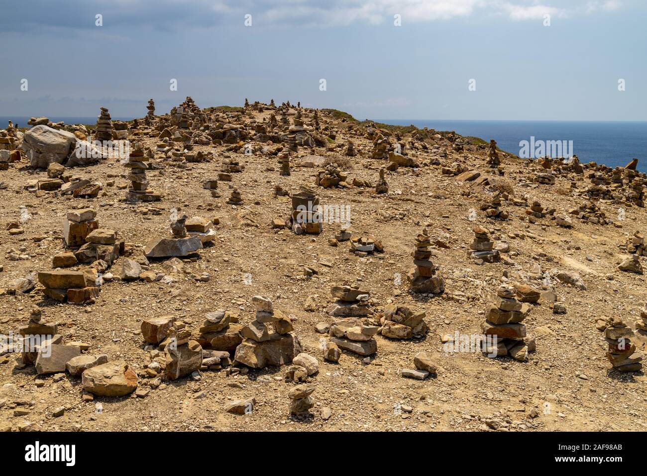 Many stacked brown stones on a hill at peninsula Prasonisi on Rhodes ...