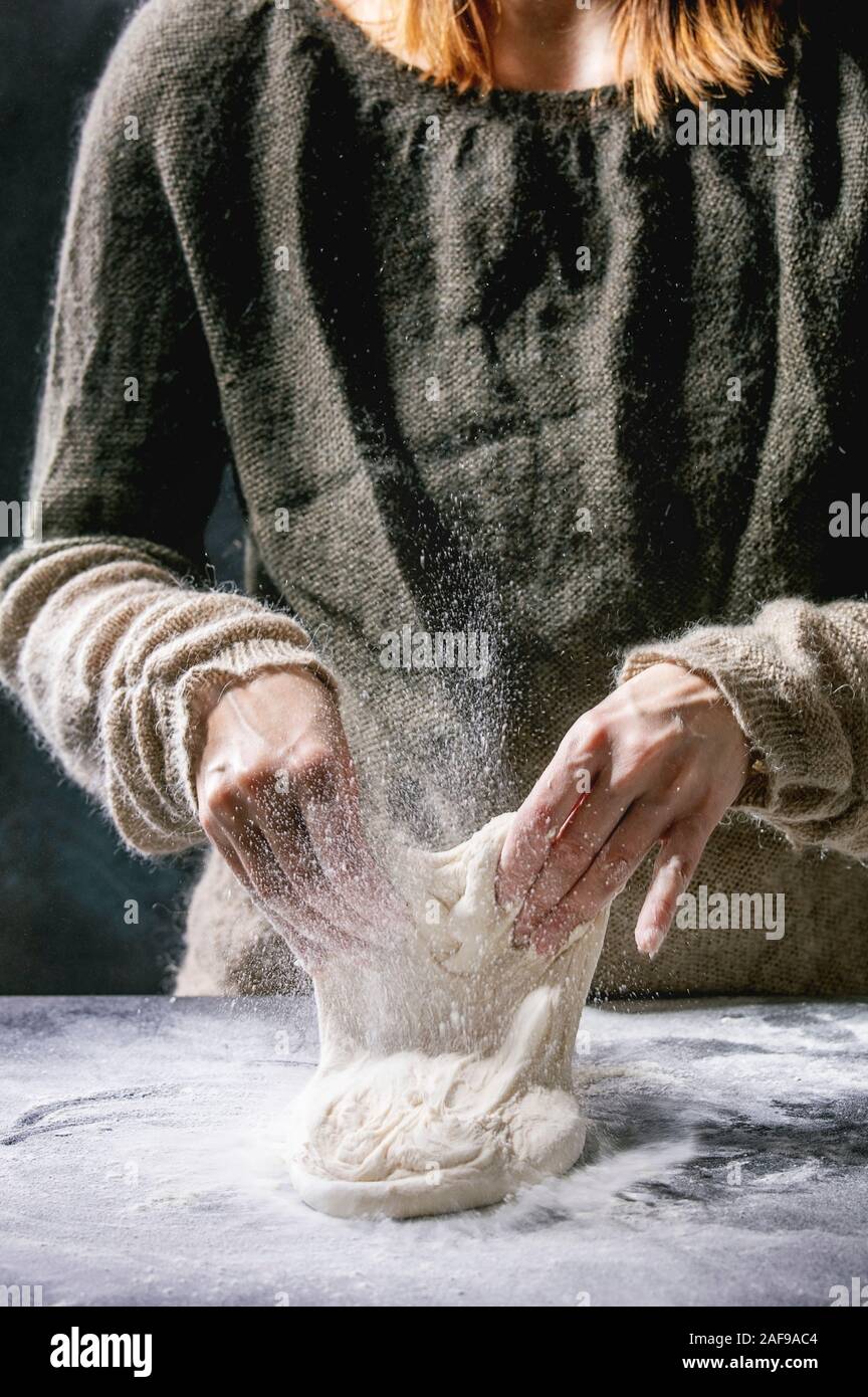 Process of making homemade bread dough. Female hands kneading dough on ...