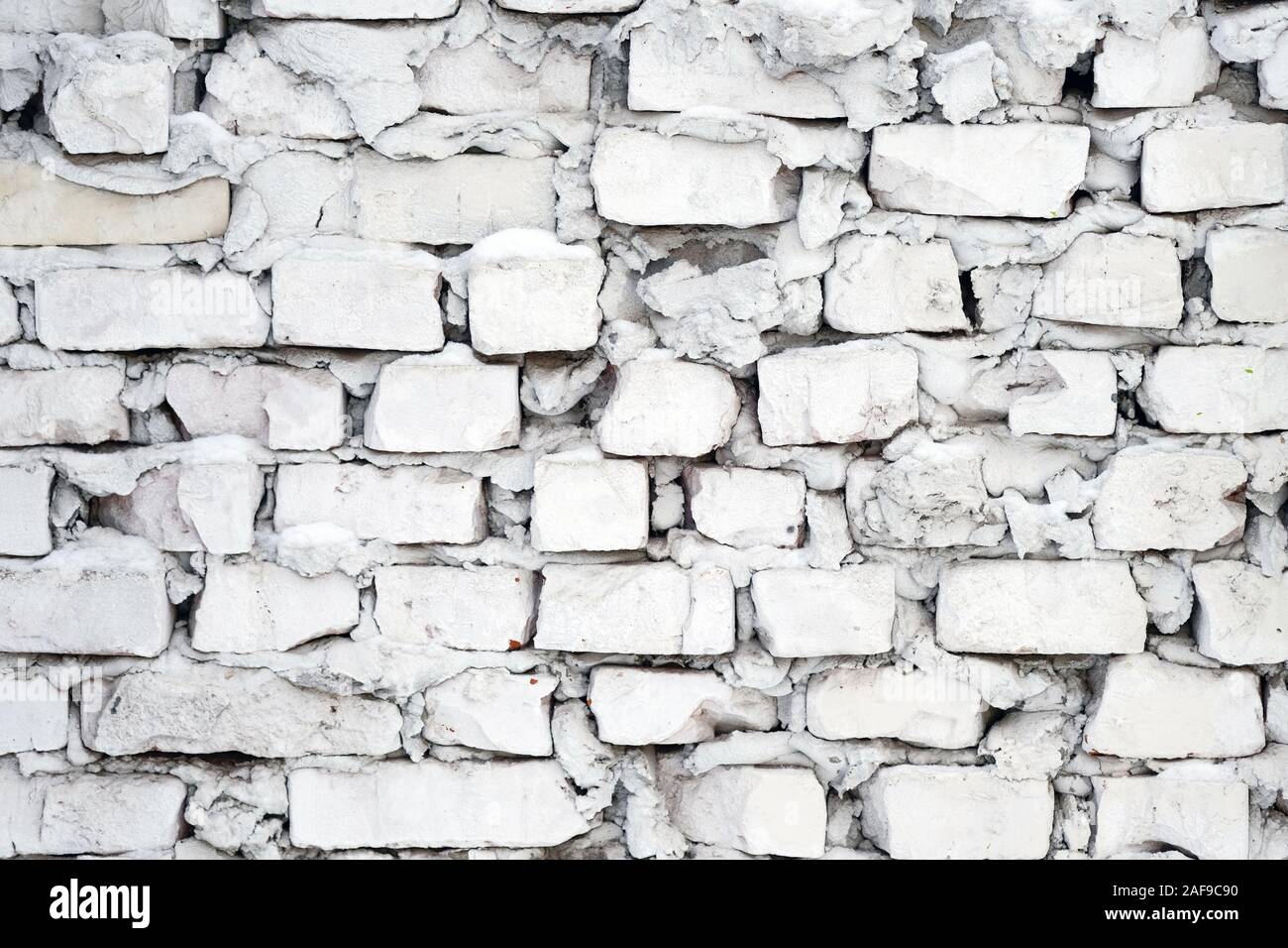 White brick wall background. gray uneven wall with pieces of cement ...