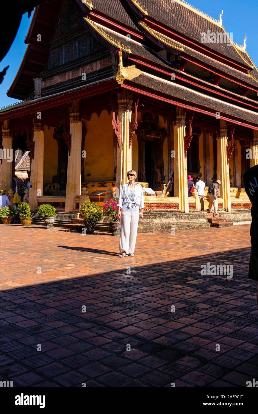 A woman and others take in the sights of one of Vientiane's many ...