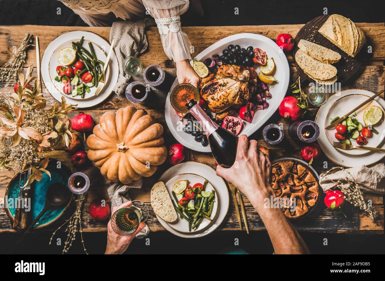 Thanksgiving party table setting. Flat-lay of people pouring champagne ...