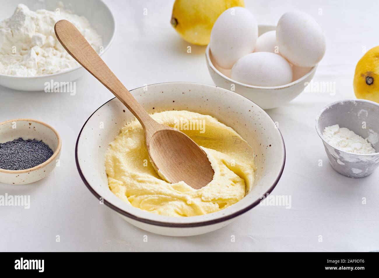 Mixing butter and sugar with wooden spoon while cooking lemon cake ...
