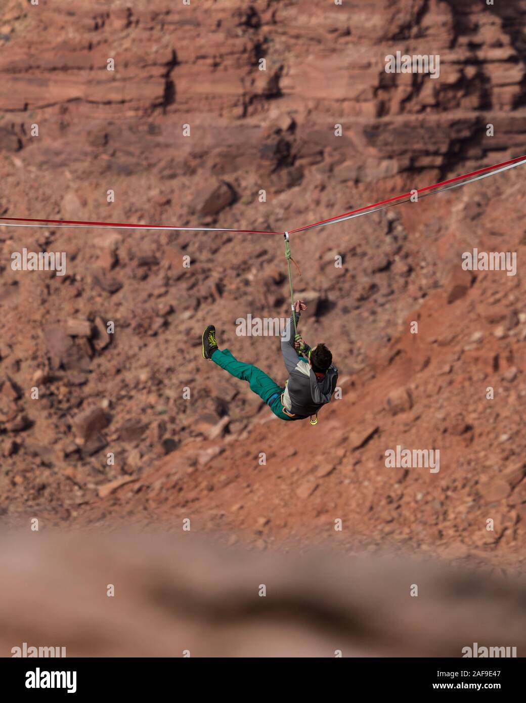 A young man loses his balance and falls while slacklining or highlining ...