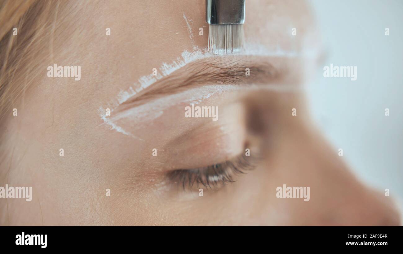 Create permanent eyebrow makeup. Marking the shape of the eyebrows ...