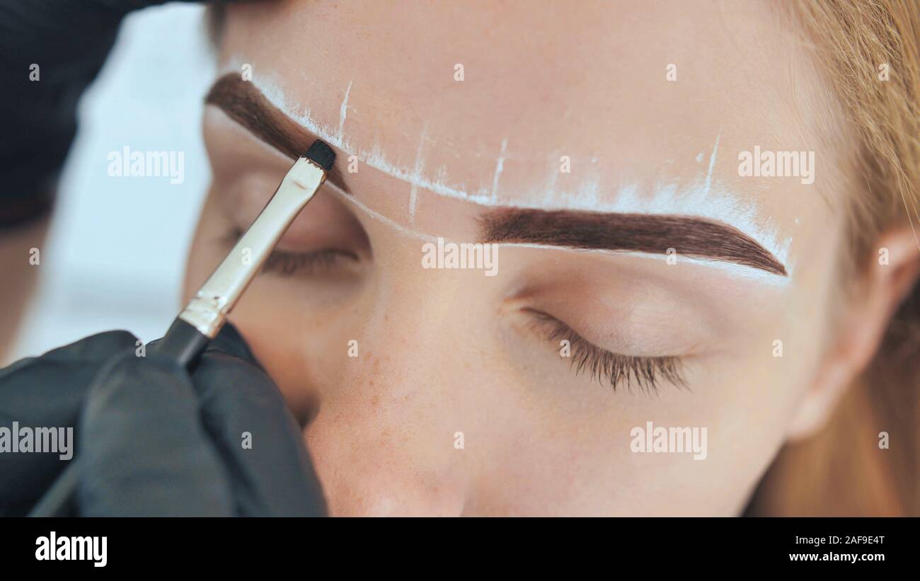 Create permanent eyebrow makeup. Marking the shape of the eyebrows ...