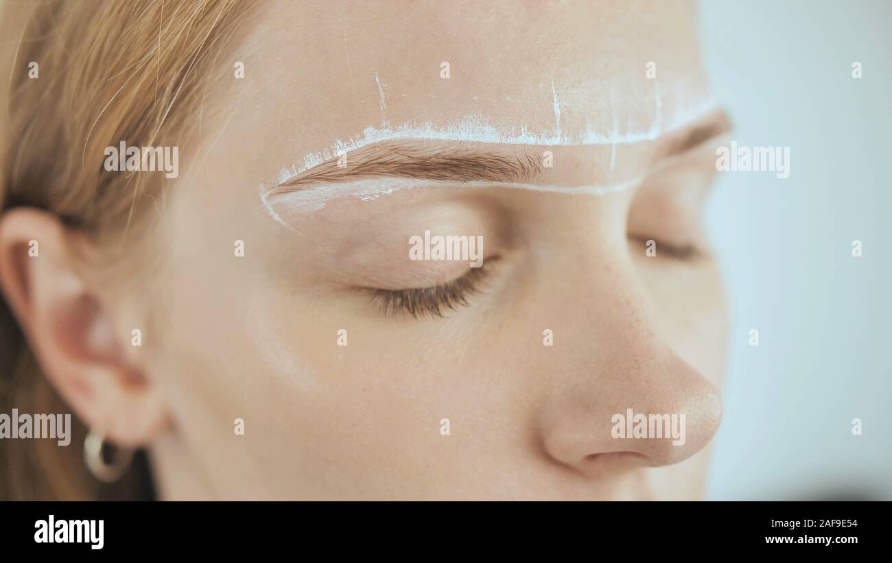 Create permanent eyebrow makeup. Marking the shape of the eyebrows ...