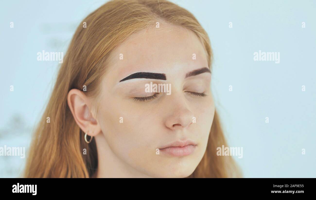 Create permanent eyebrow makeup. Marking the shape of the eyebrows ...