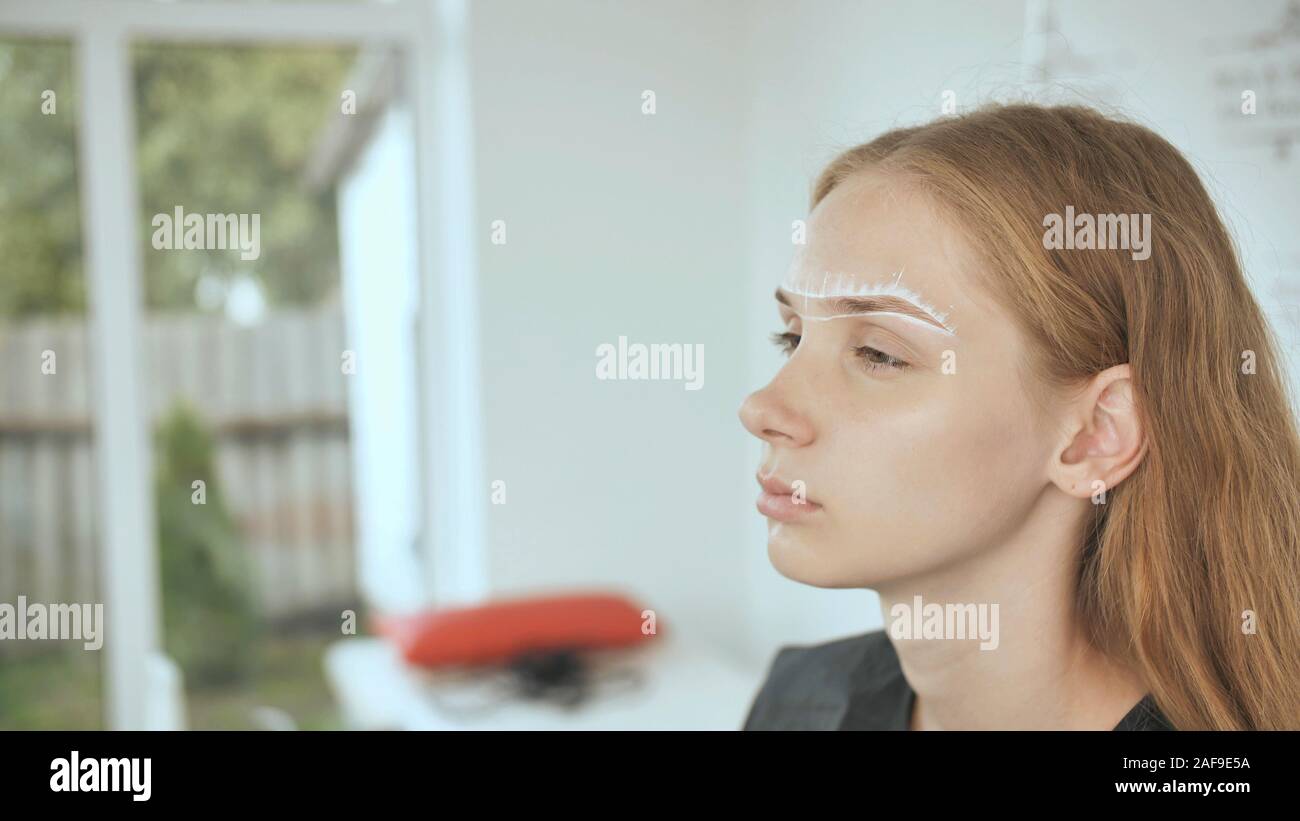 Create permanent eyebrow makeup. Marking the shape of the eyebrows ...