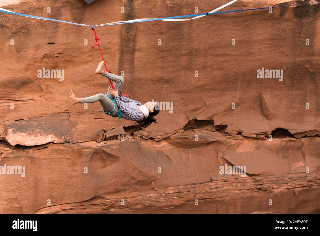 A young woman loses her balance and falls while slacklining or ...
