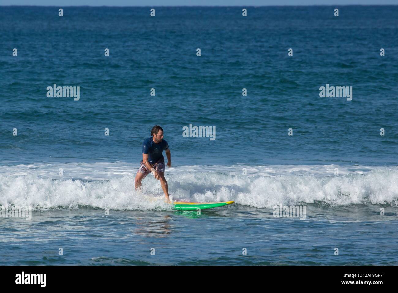 A tourist catches a wave surfing in Hanalei Bay, Kauai, Hawaii Stock ...