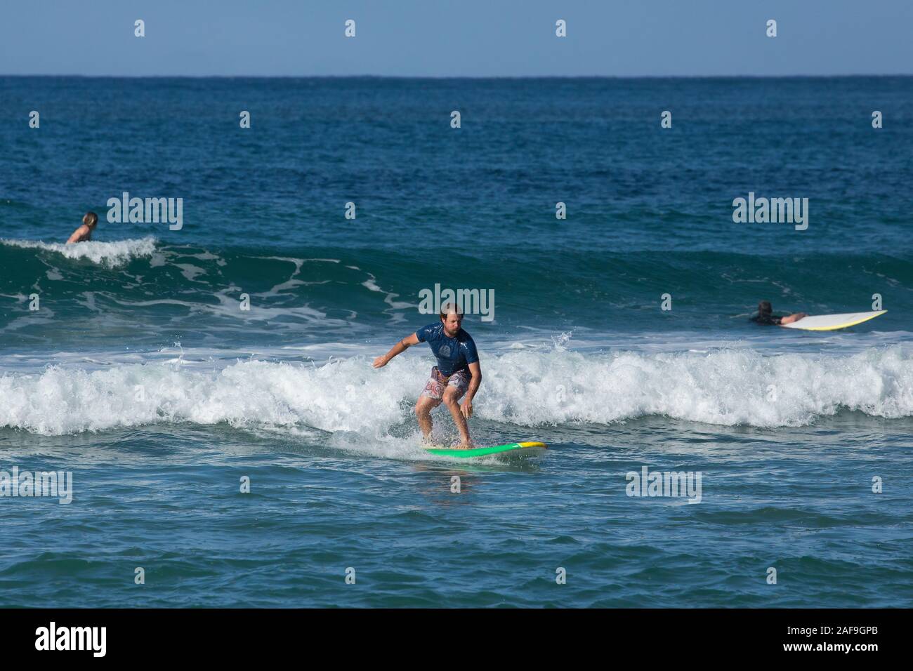 A tourist catches a wave surfing in Hanalei Bay, Kauai, Hawaii Stock ...