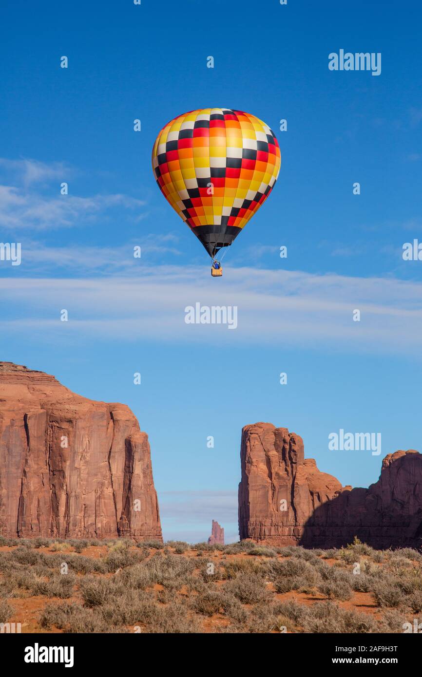A hot air balloon flying between Cly Butte and Spearhead Mesa in the ...