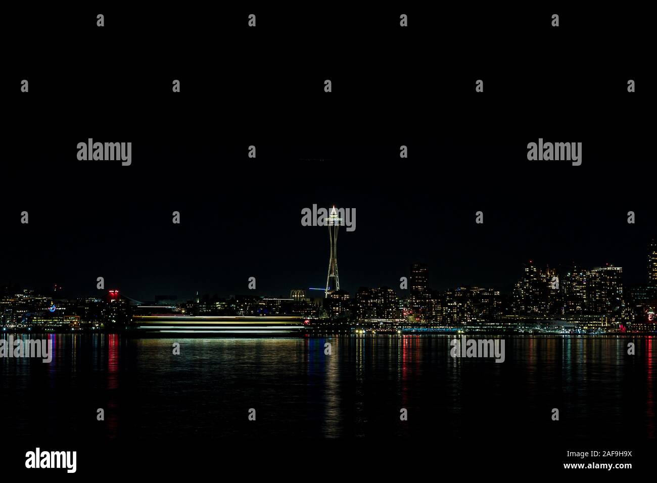 Long exposure ferry boat crossing under illuminated Seattle skyline ...
