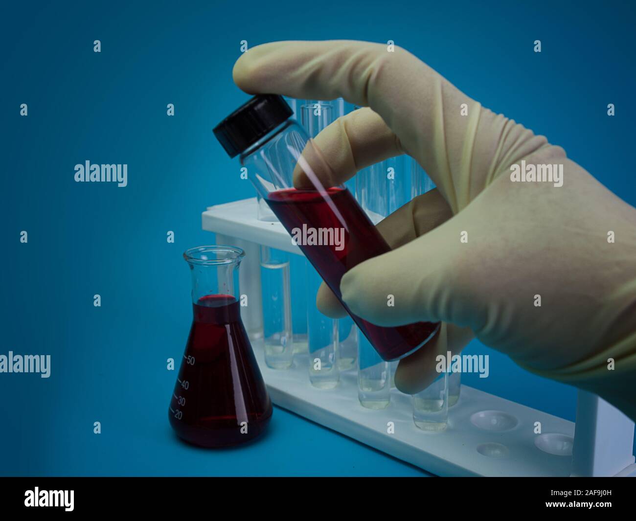 scientist hand holding laboratory test tube , Blue background Stock ...