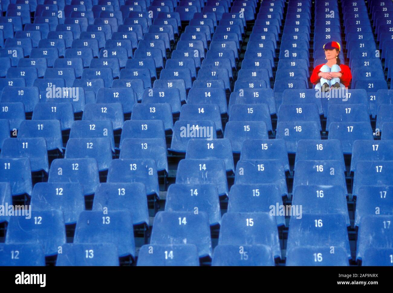 LONE FEMALE SPECTATOR SITTING IN OUTDOOR SPORT STADIUM, AUSTRALIA Stock ...