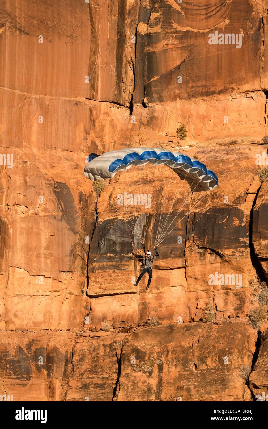 A BASE jumper descends in his parachute off the 400 foot vertical face ...