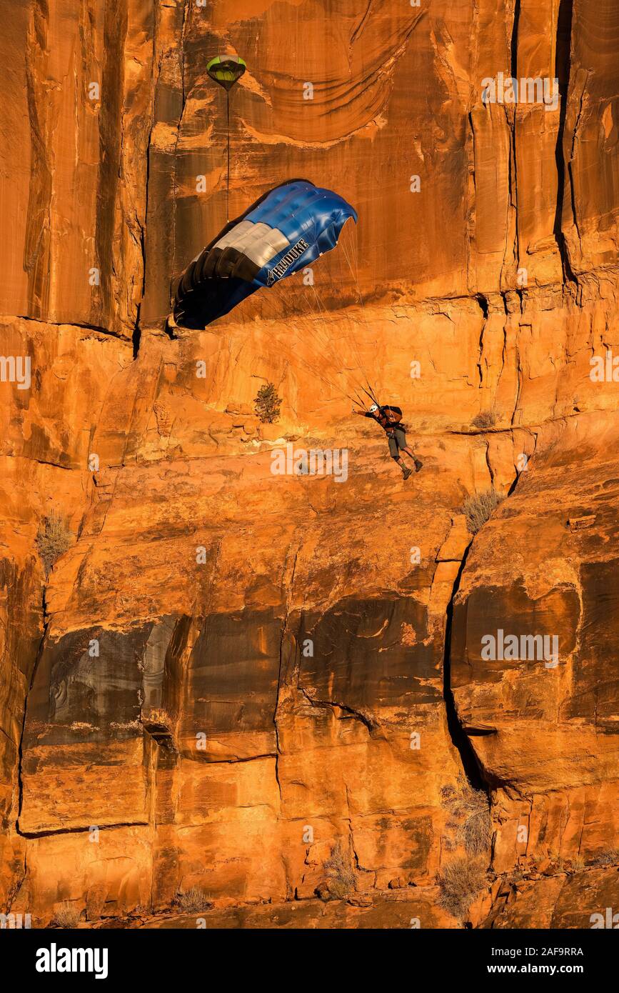 A BASE jumper descends in his parachute off the 400 foot vertical face ...