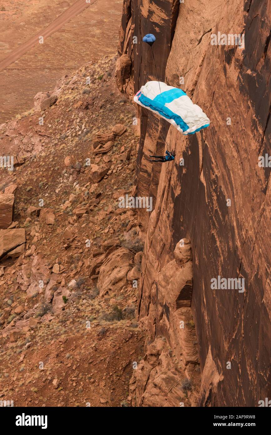 A female BASE jumper descends in her parachute from the Mothership ...