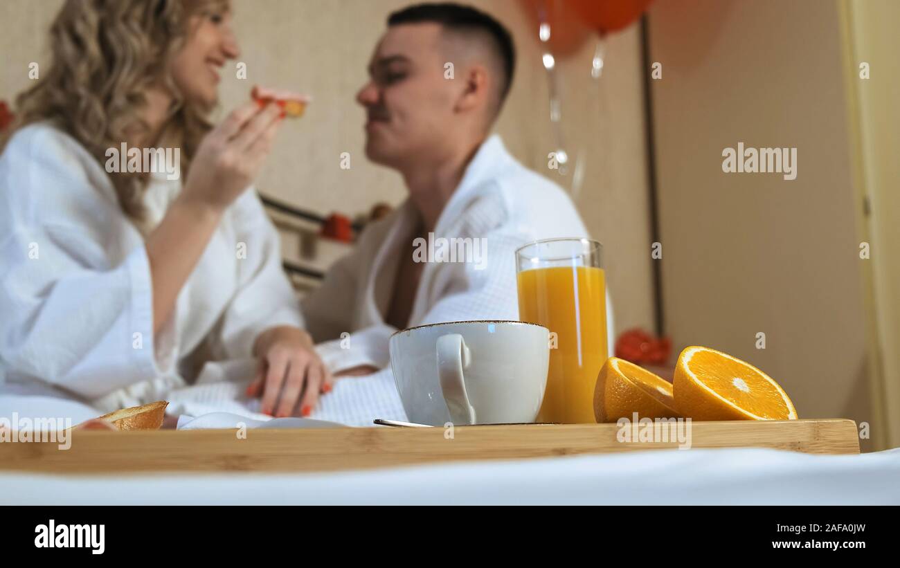 Young couple lovers romantic breakfast in bed. Lovely girlfriend feeds ...