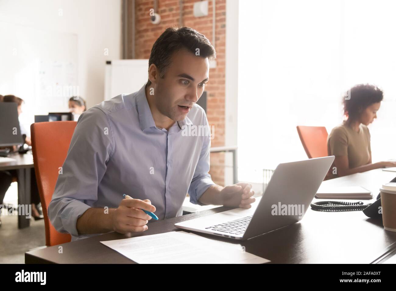 Shocked confused office worker looking at laptop screen Stock Photo - Alamy