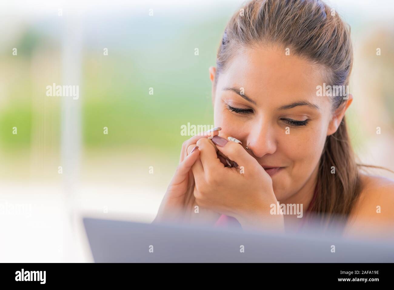 Beautiful woman smiles at the laptop screen Stock Photo - Alamy