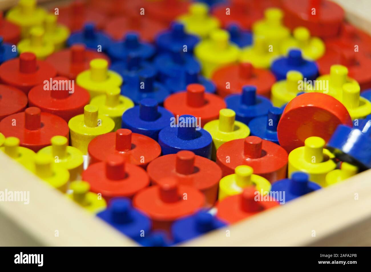 childrens games with red, yellow and blue wooden pieces Stock Photo - Alamy