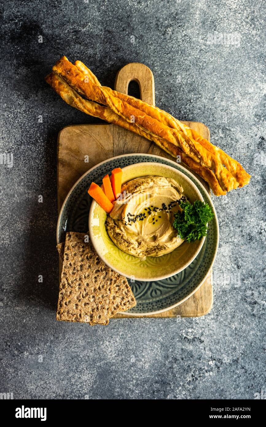 Traditional chickpeas hummus with olive oil and sesame seeds on stone ...