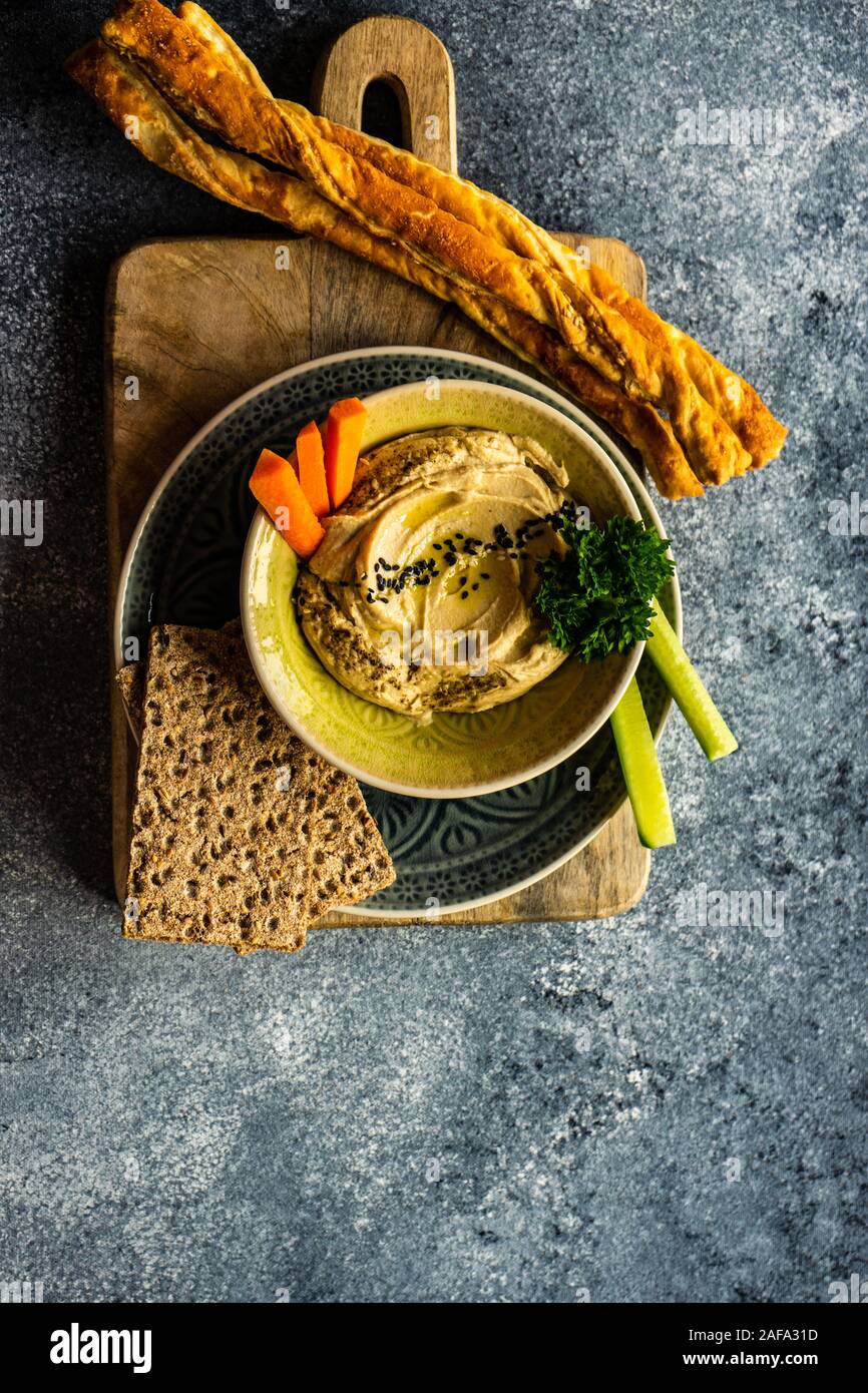 Traditional chickpeas hummus with olive oil and sesame seeds on stone ...