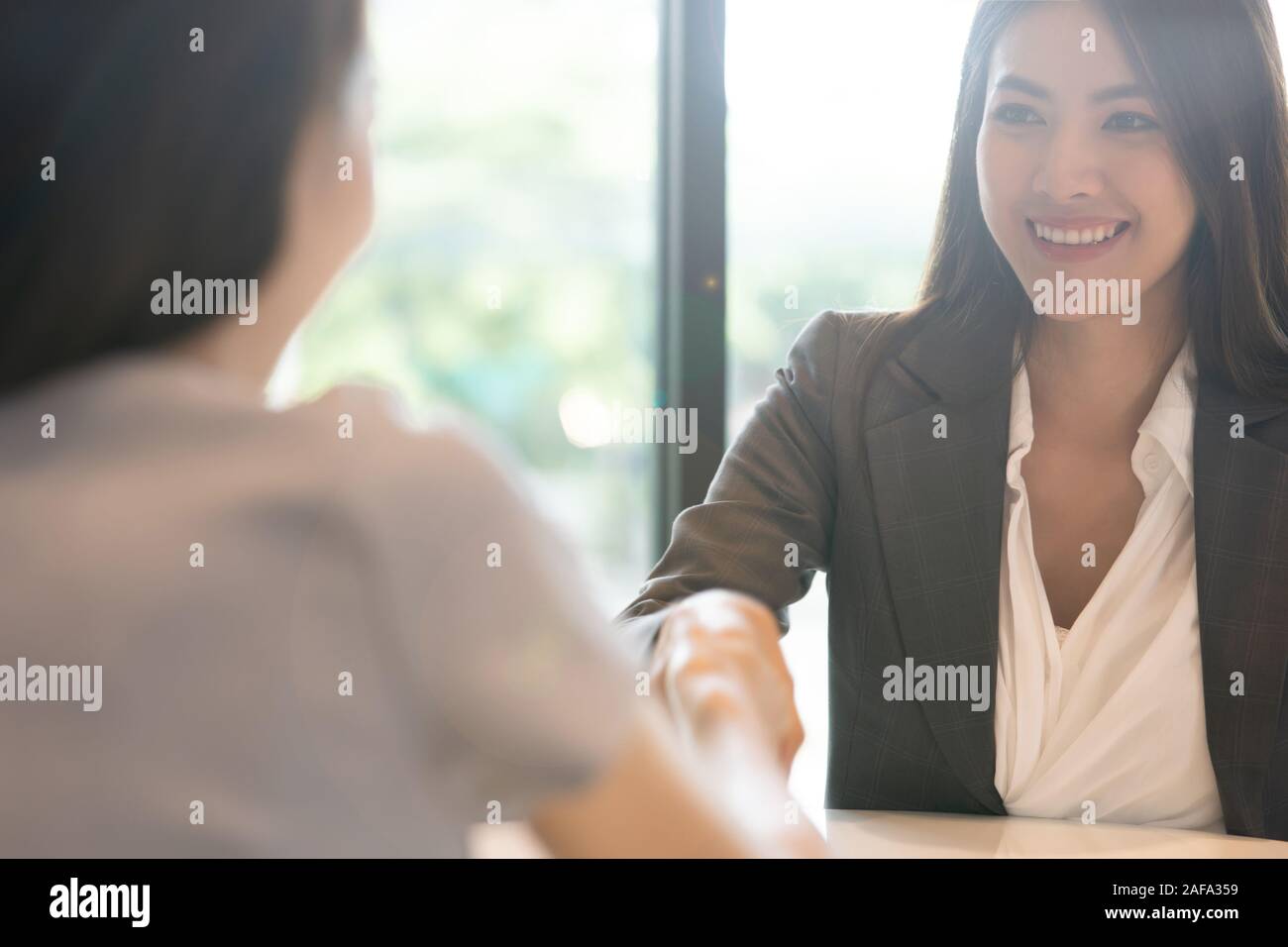 Portrait young Asian woman interviewer and interviewee shaking hands ...