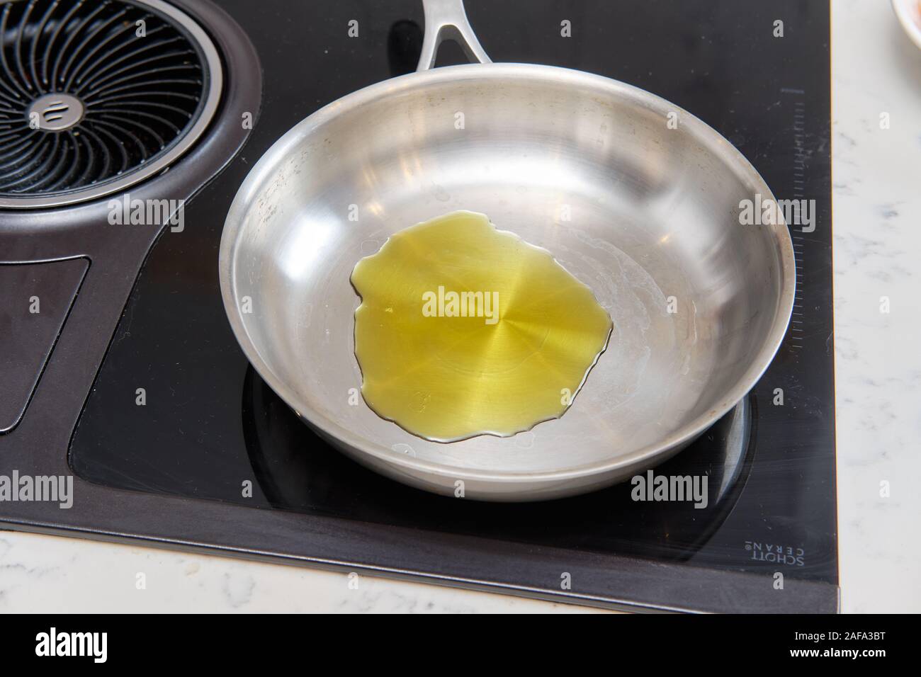 Frying pan with olive oil on the stove Stock Photo - Alamy