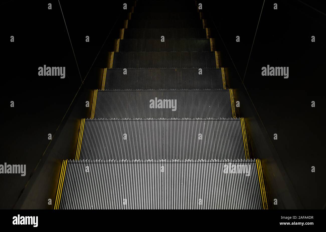 Escalator in an underground station dark background Stock Photo - Alamy