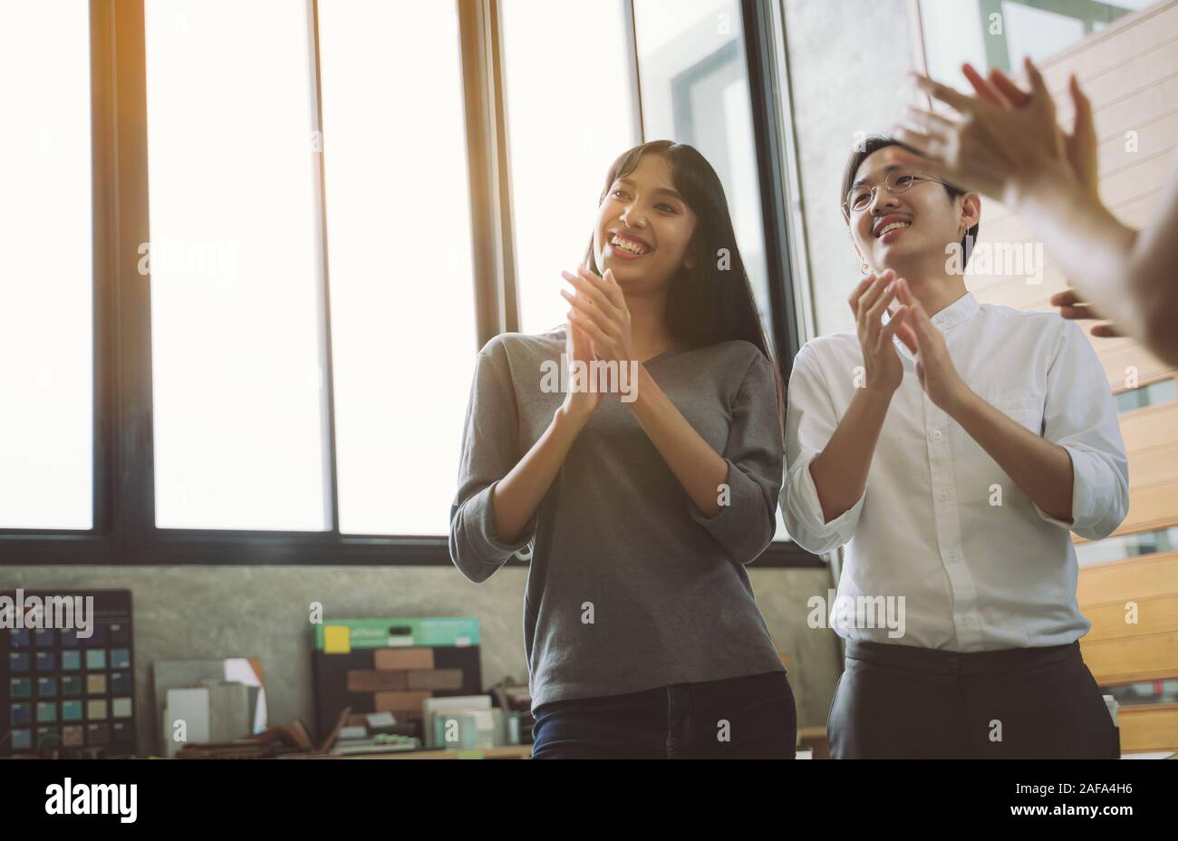 Young Asian creative business people clapping hands at the meeting ...