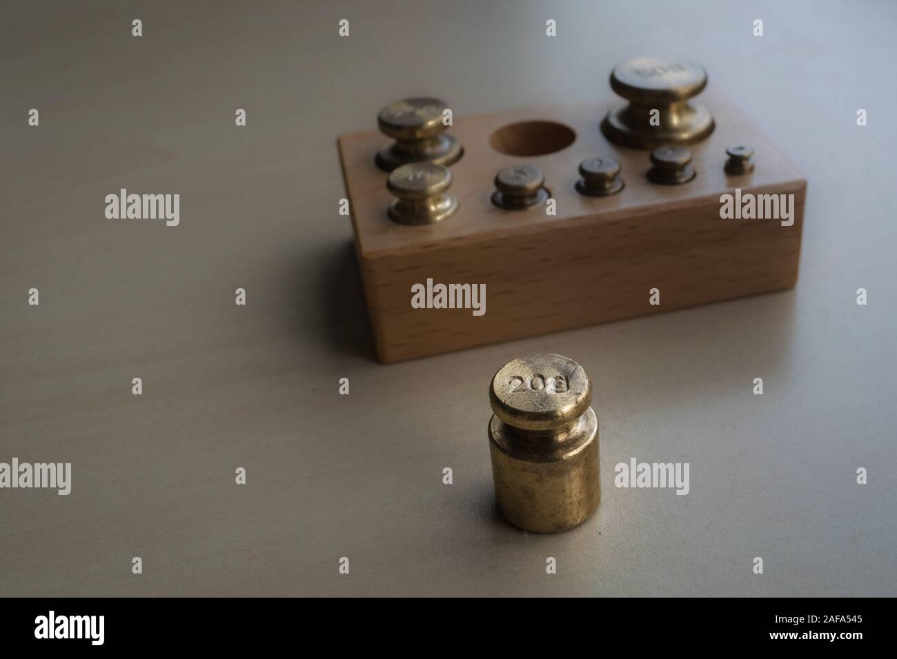 Weight of 20 gram originating from wooden box in the background. Weight ...