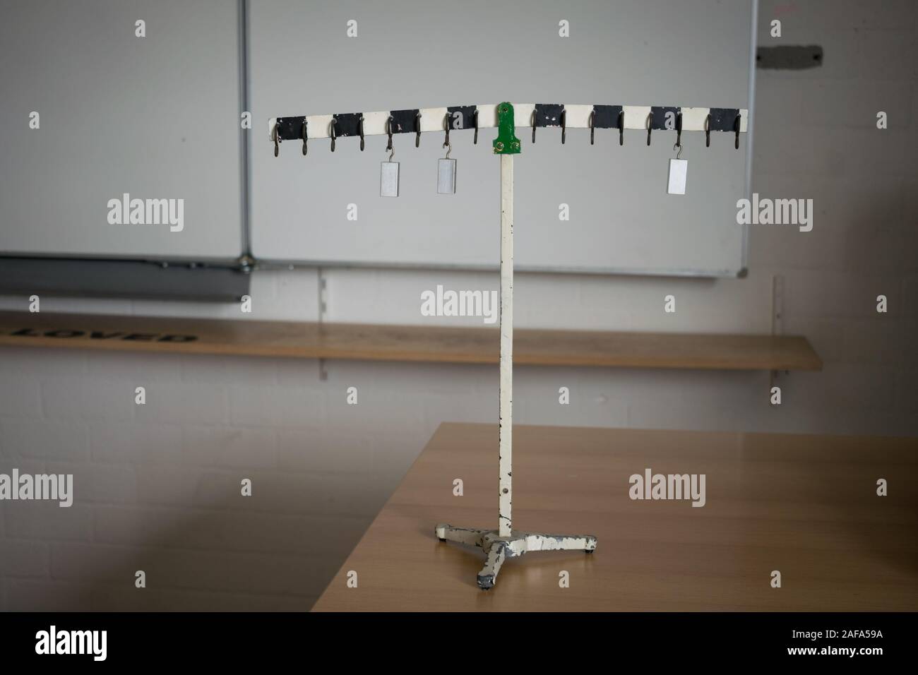 Physics experiment with balance and weights demonstrating the principle ...