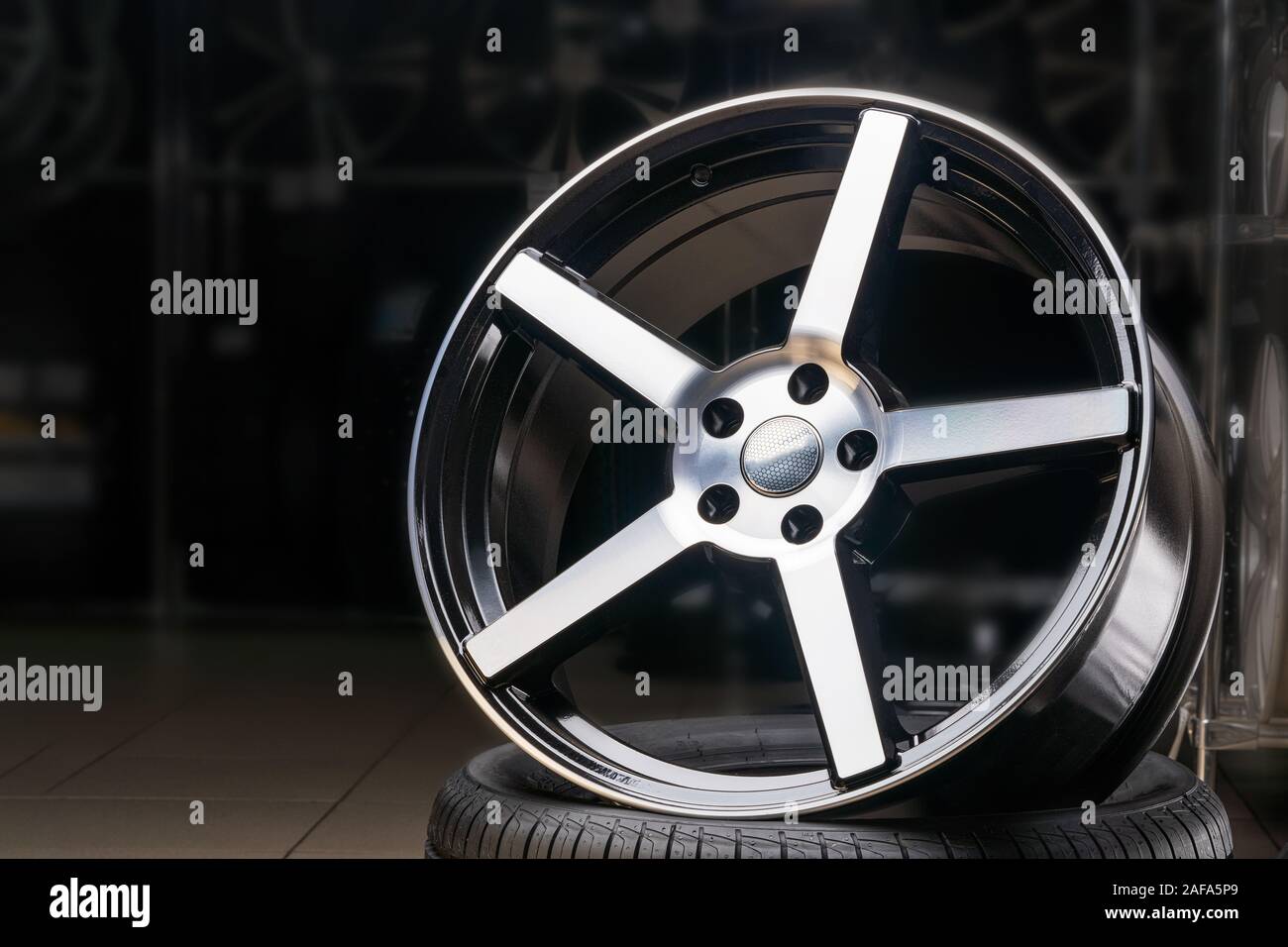 cast aluminum disc alloy wheel modern, close-up on black background ...