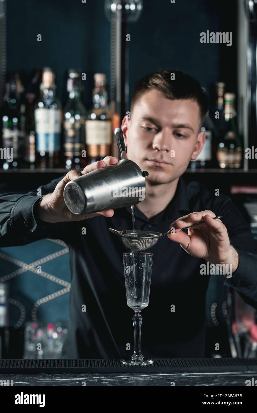 bartender making French 75 Cocktail pouring fluid into glass. Bar on a background Stock Photo ...