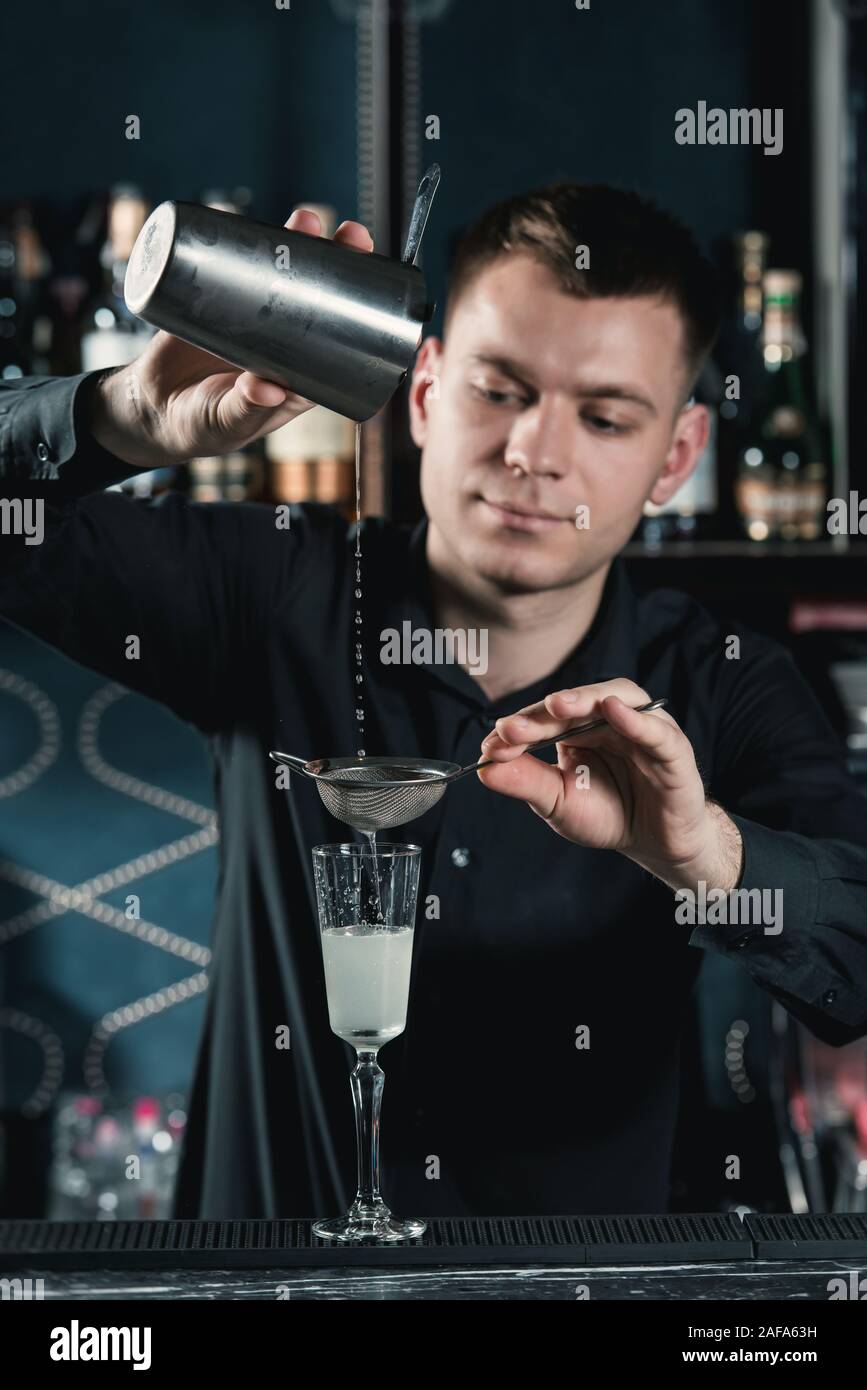 bartender making French 75 Cocktail pouring fluid into glass. Bar on a background Stock Photo ...