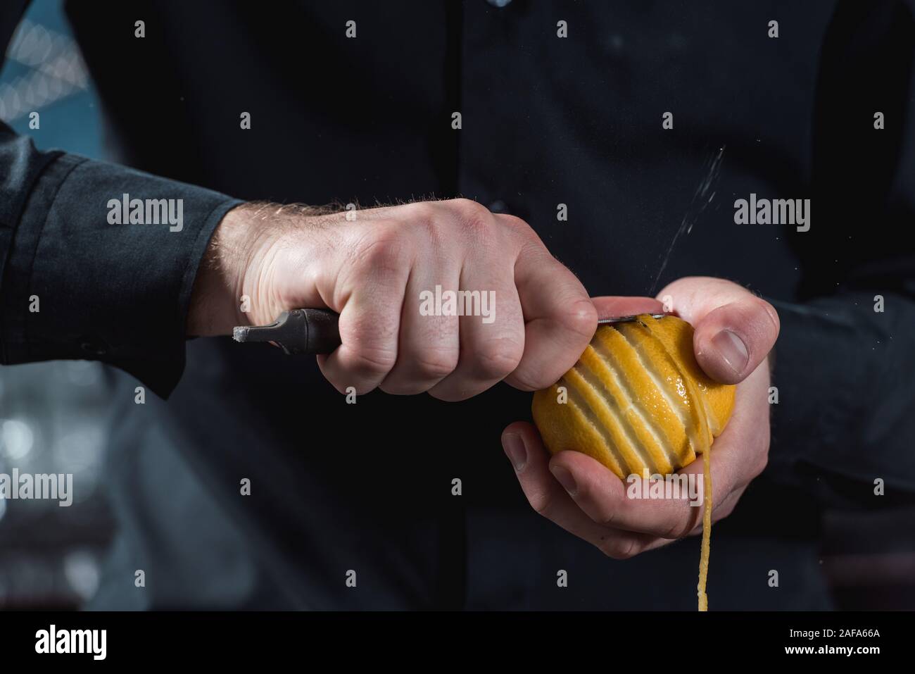 bartender making cocktail. slicing a long ribbon of lemon peel Stock ...