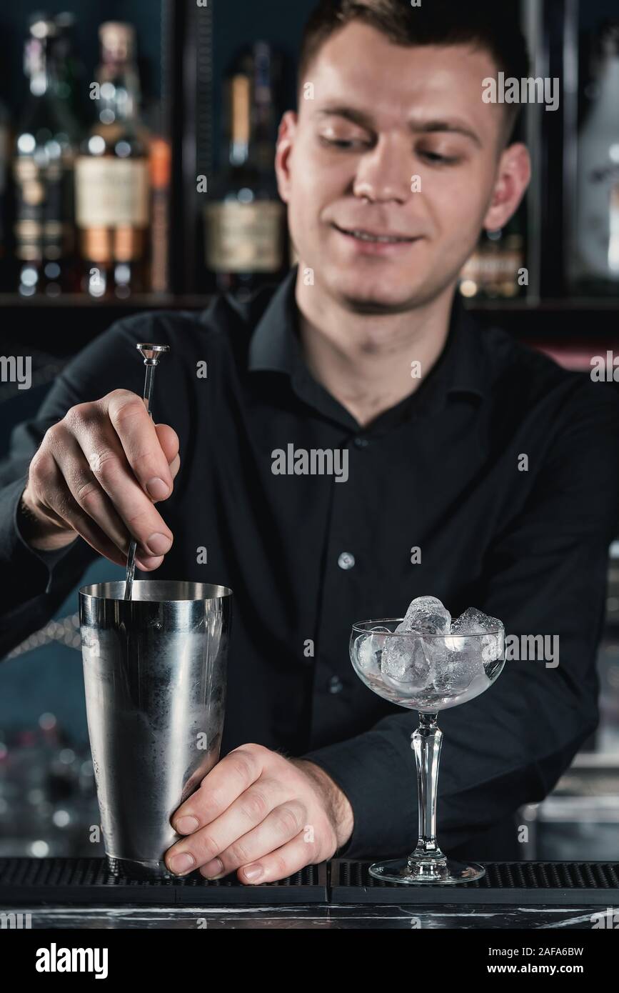 bartender making Boulevardier Cocktail pouring fluid into glass. Bar on a background Stock Photo ...