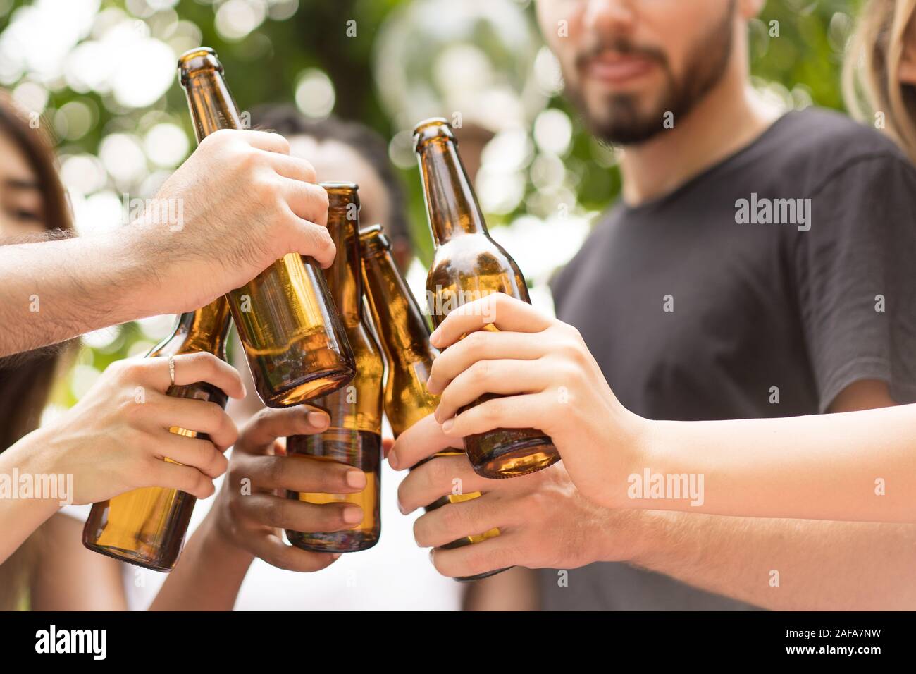 Group of friends toasting beers outdoors. Party people drinks toast ...