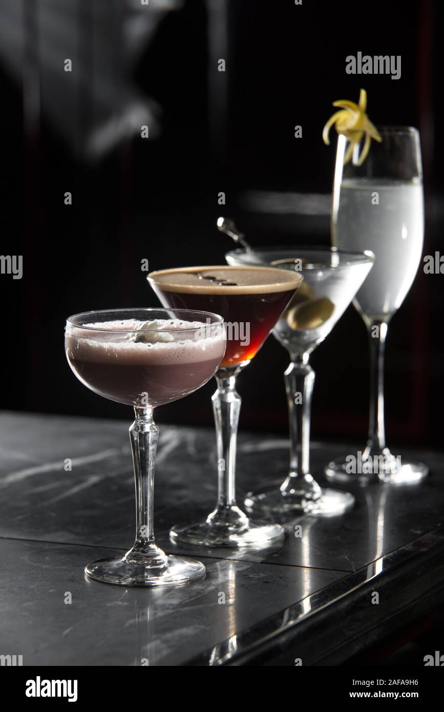 four special cocktails on a bar desk. black background Stock Photo - Alamy