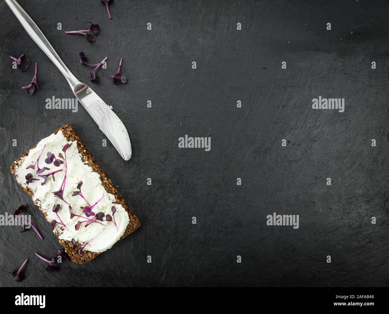 Slate slab with cream cheese and fresh cress on a slice of wholemeal ...