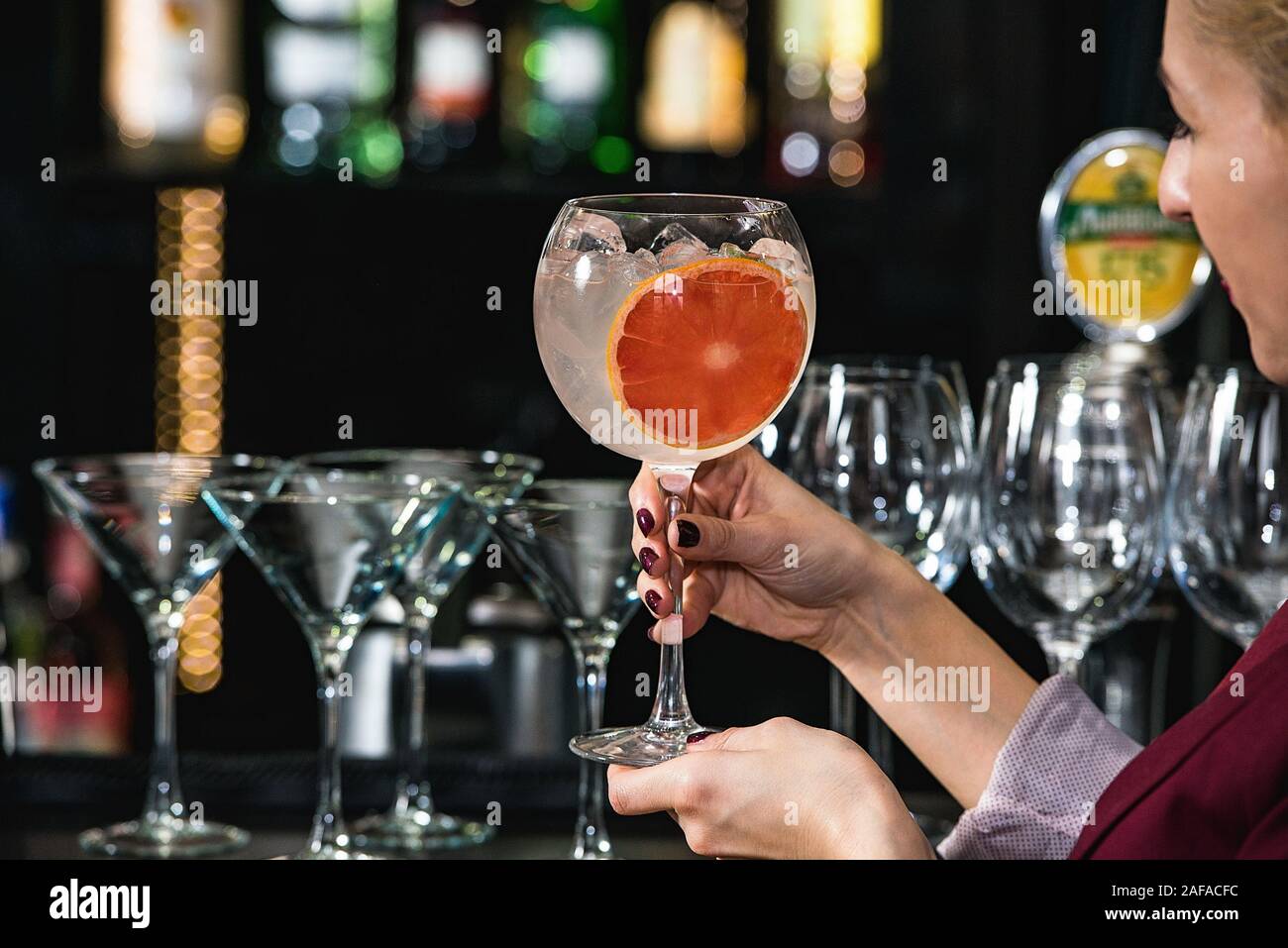 refreshing ruby red coctail with grape fruit isolated on a bar ...